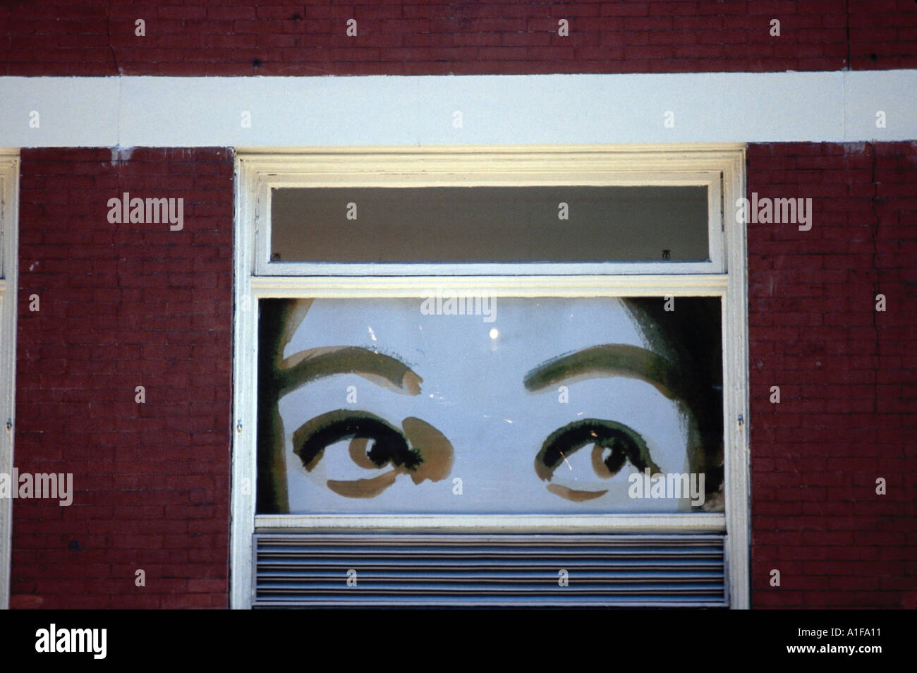 A window covered with a poster of a woman's eyes Stock Photo - Alamy
