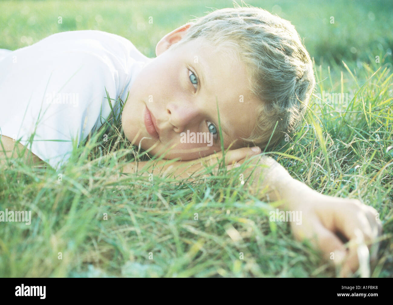 Boy lying in grass Stock Photo - Alamy