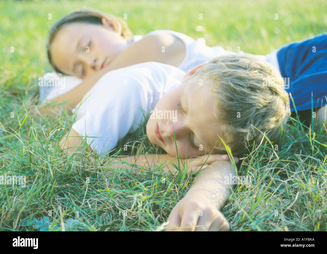 Boy girl sleeping in grass hi-res stock photography and images - Alamy