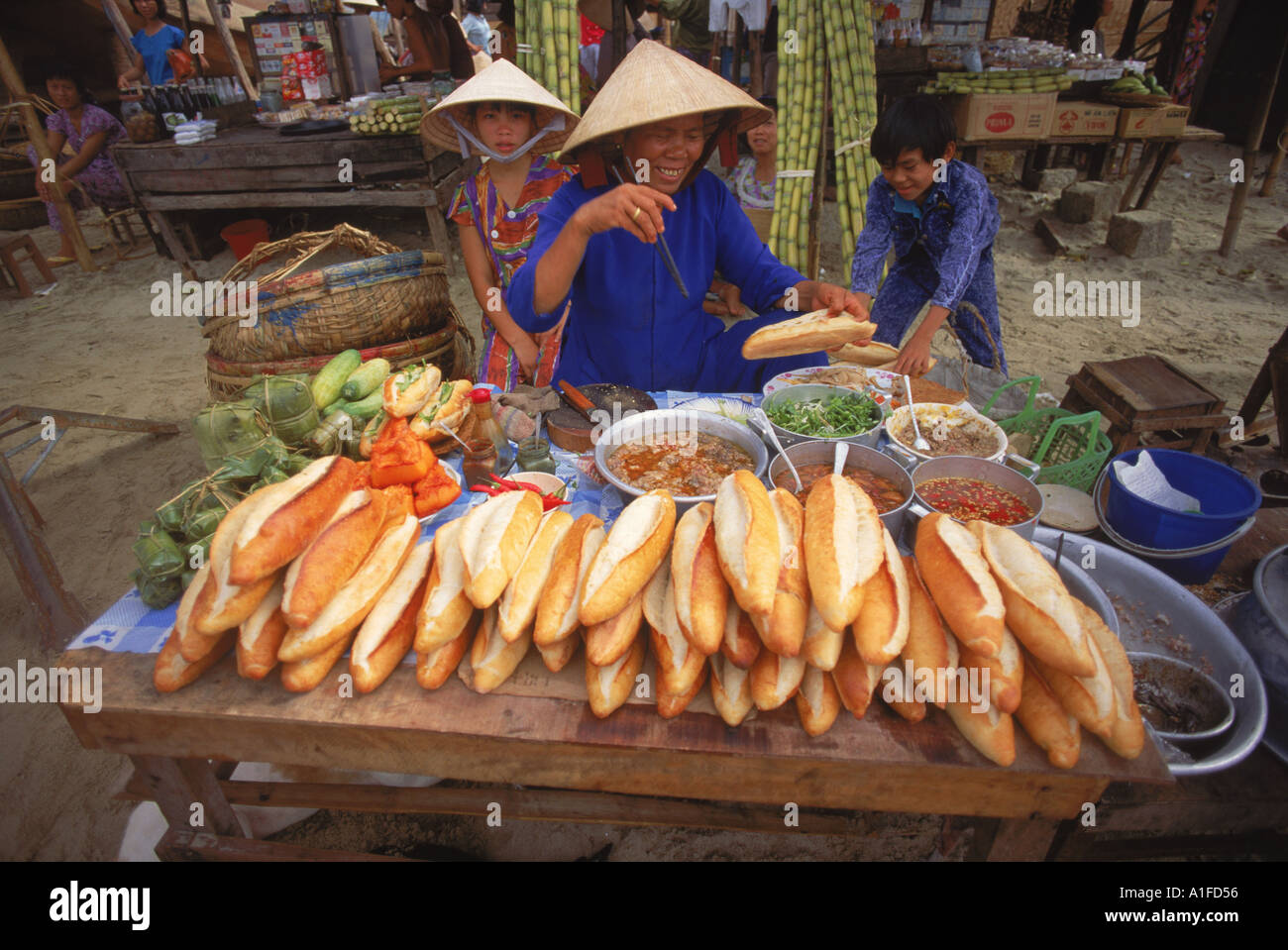 Woman street vendor selling French bread sandwiches from her stall on ...