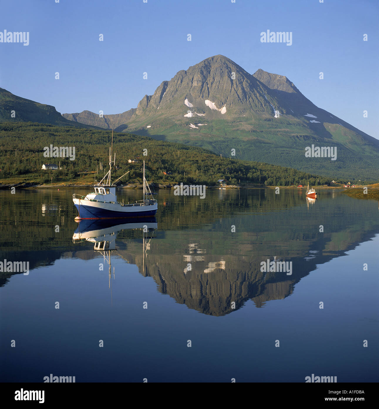 Reflection of fishing boat and landscape in still water at Ryoy near ...