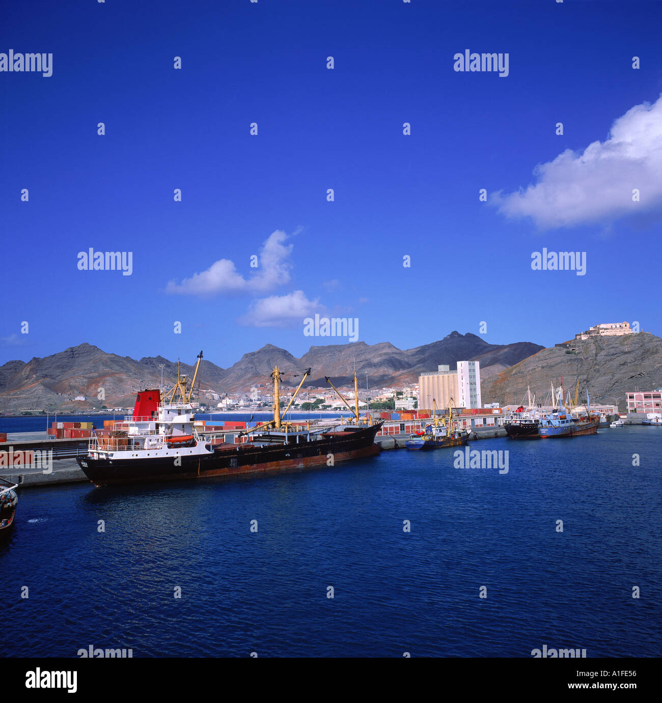 Cargo ships in port with the town and mountains in the background at ...