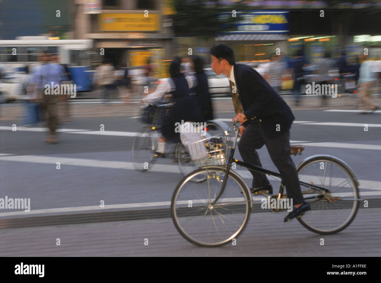 Man riding a bike through the streets of Kumamoto Kyushu Japan Asia P ...