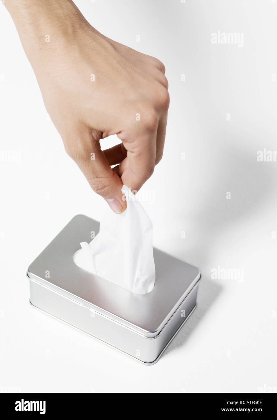 Hand taking tissue from dispenser Stock Photo - Alamy