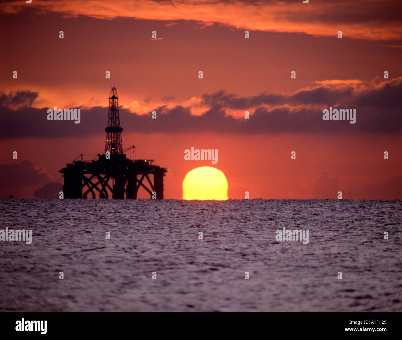 Oil rig at sunset Stock Photo - Alamy