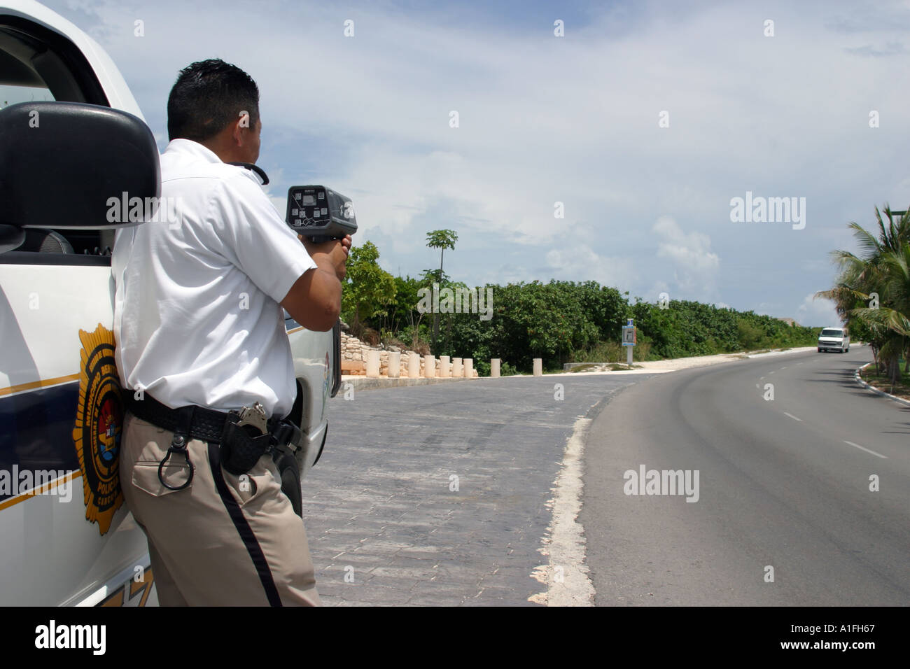 Policeman checking speed limit with a radar gun Cancun Mexico Stock ...