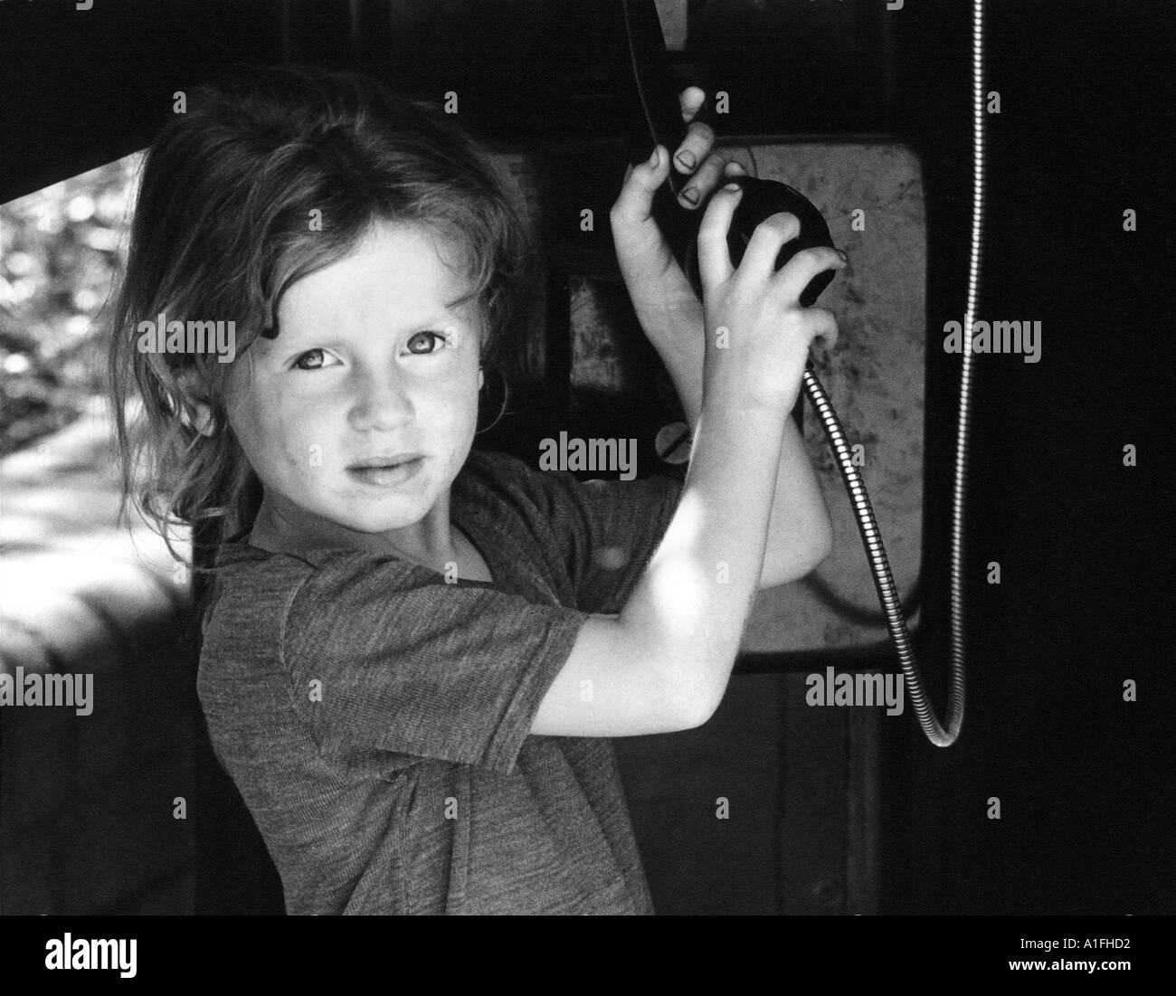 Child reaching for telephone in street kiosk Stock Photo - Alamy