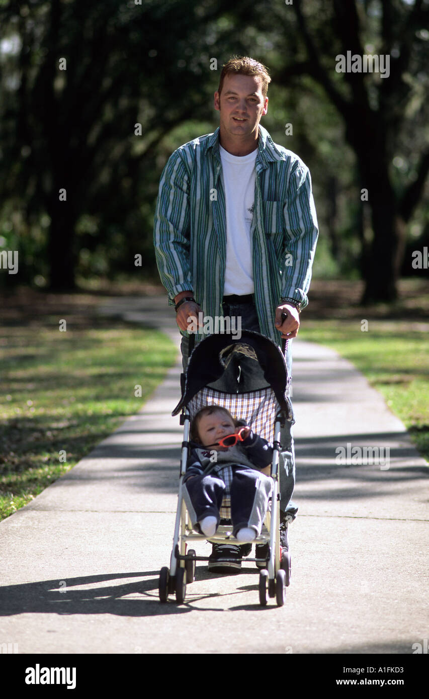 Father pushing his infant son in a stroller Stock Photo - Alamy