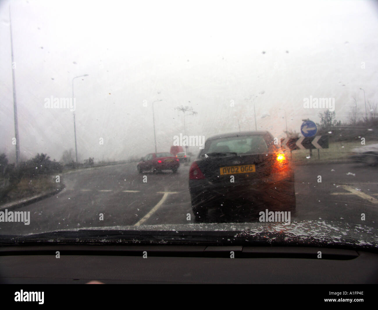 Driving in winter hazardous road conditions viewed through windscreen ...