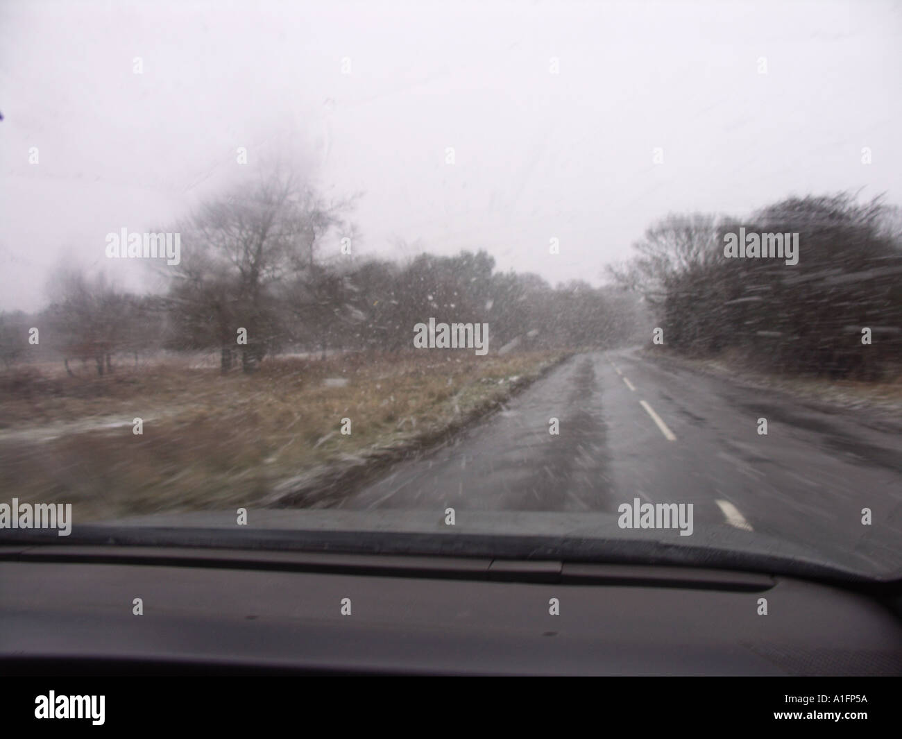 Driving in winter hazardous road conditions viewed through windscreen ...