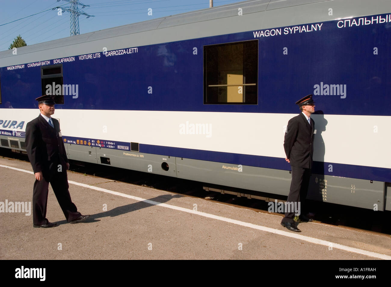 Two railway guards or conductors standing on platform near modern Inter ...