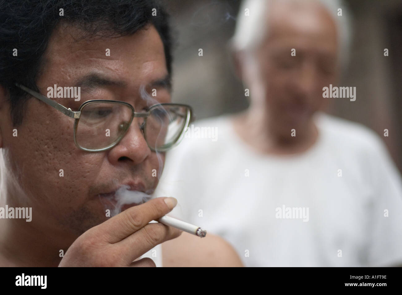 China man lighting a cigarette hi-res stock photography and images - Alamy