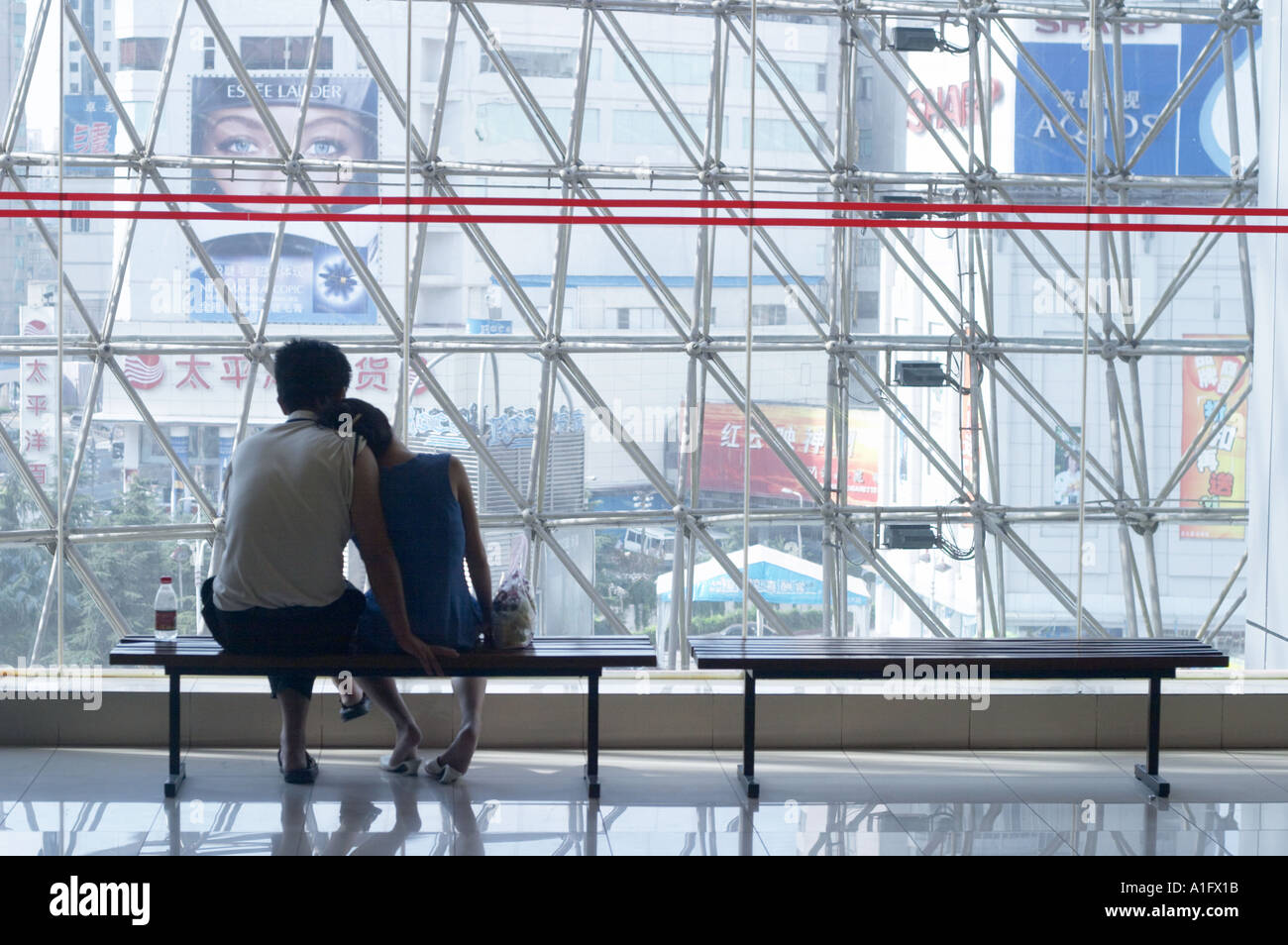 young chinese lovers in love showing affection on bench in sihuette in ...