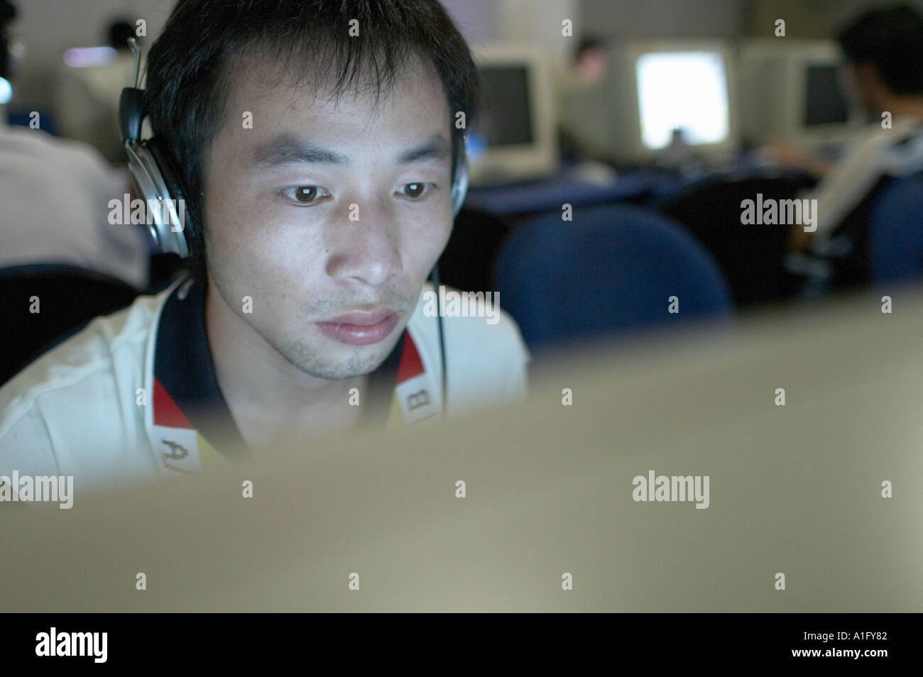 man looking intensely at computer screen in internet cafe shanghai ...