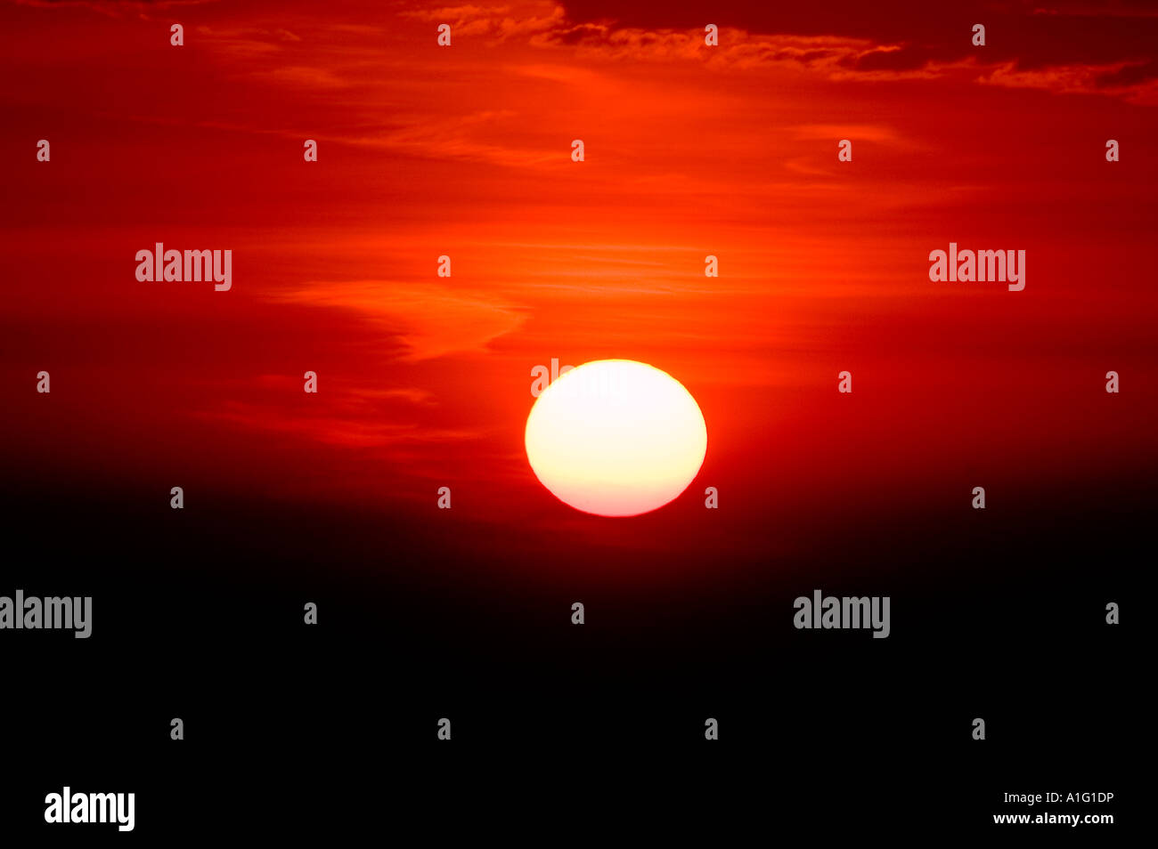 Scenic close up of blood red sunset with red clouds and black terrain Stock Photo - Alamy