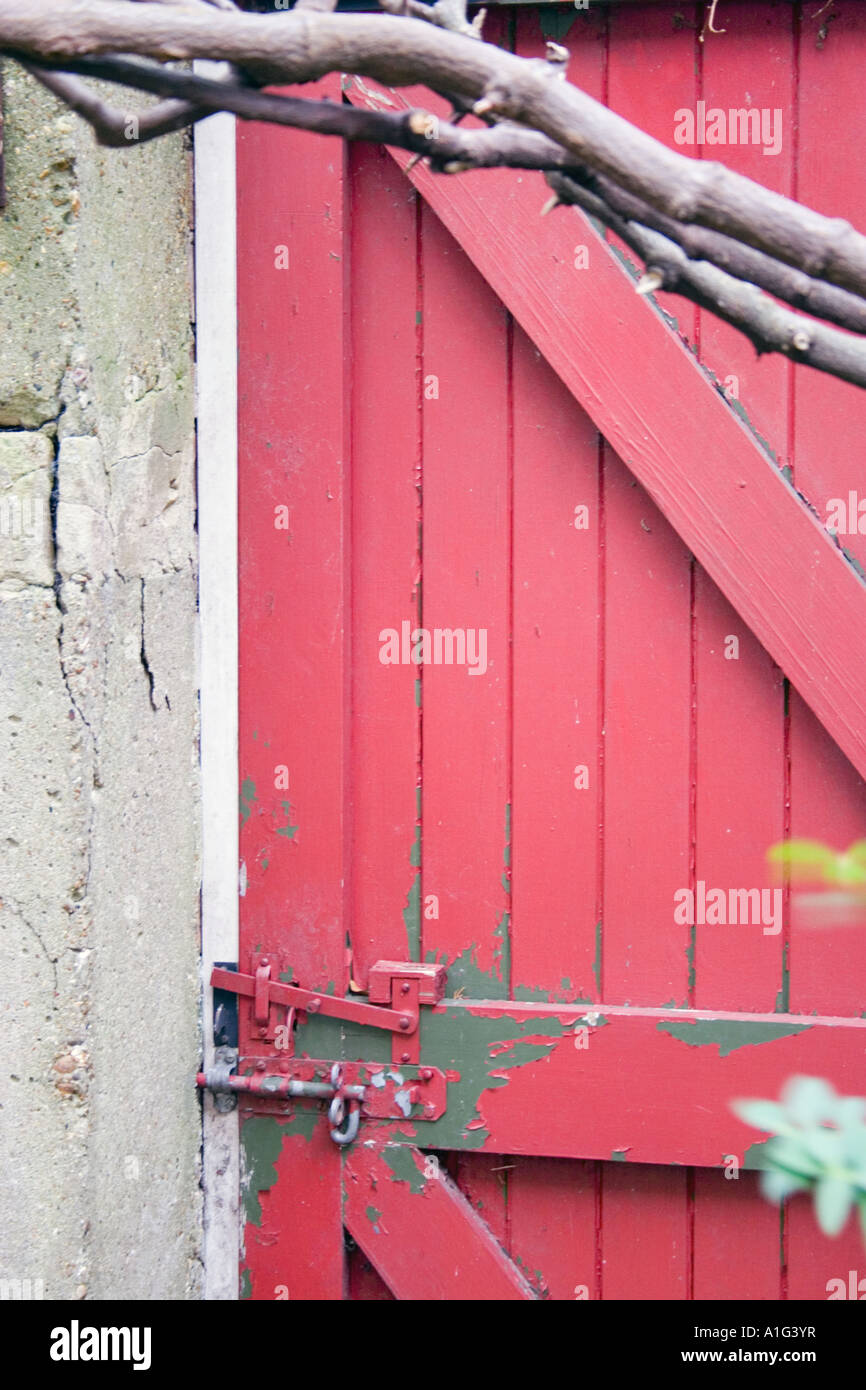 Rustic red door with branches England Stock Photo - Alamy
