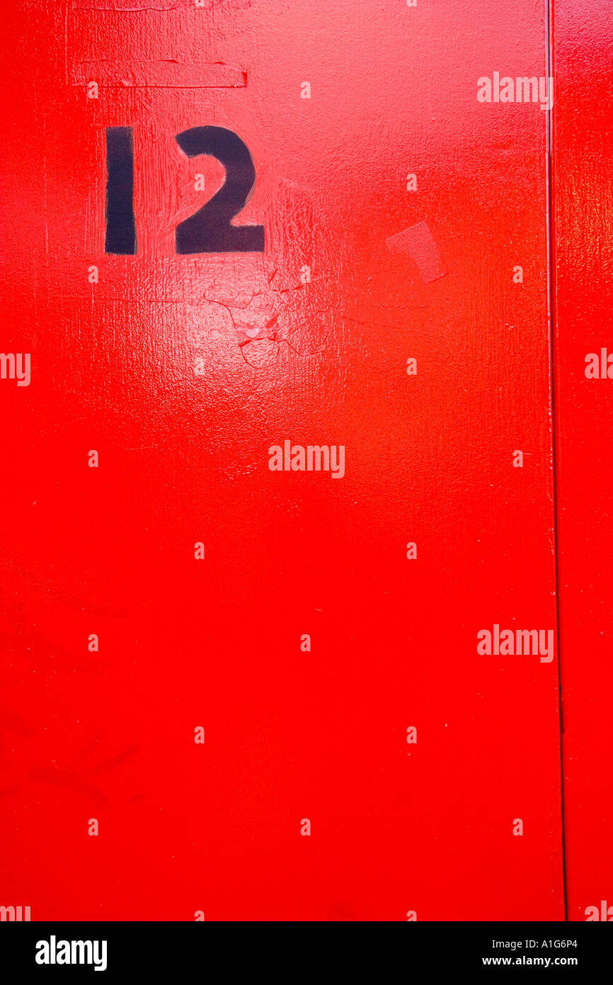 Colourful number 12 on red door Stock Photo - Alamy