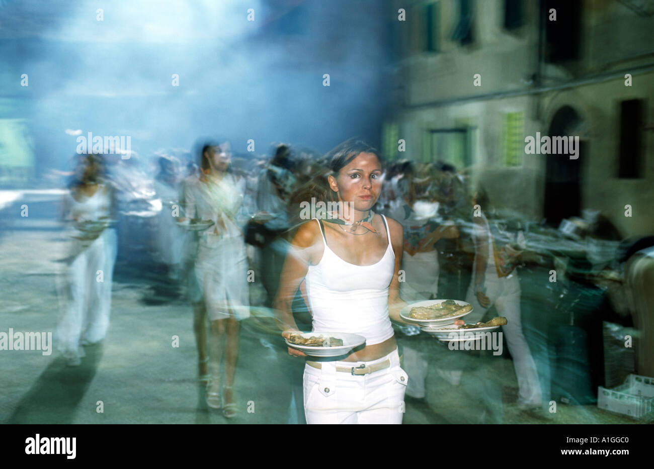 Girls in white serve food for Contrada Lupa dinner guests night before ...