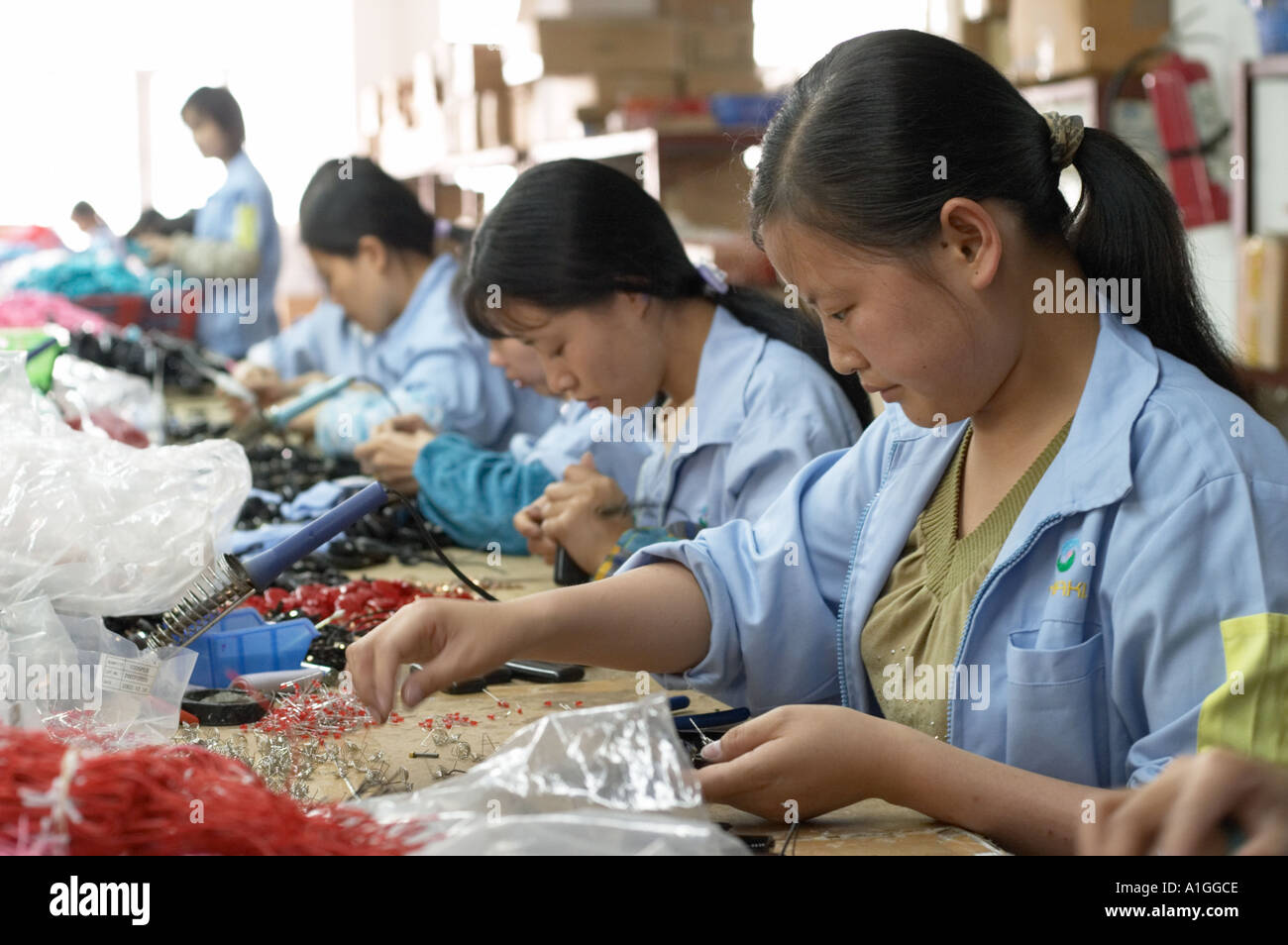 Migrant factory workers making electrical parts in factory in shenzhen ...