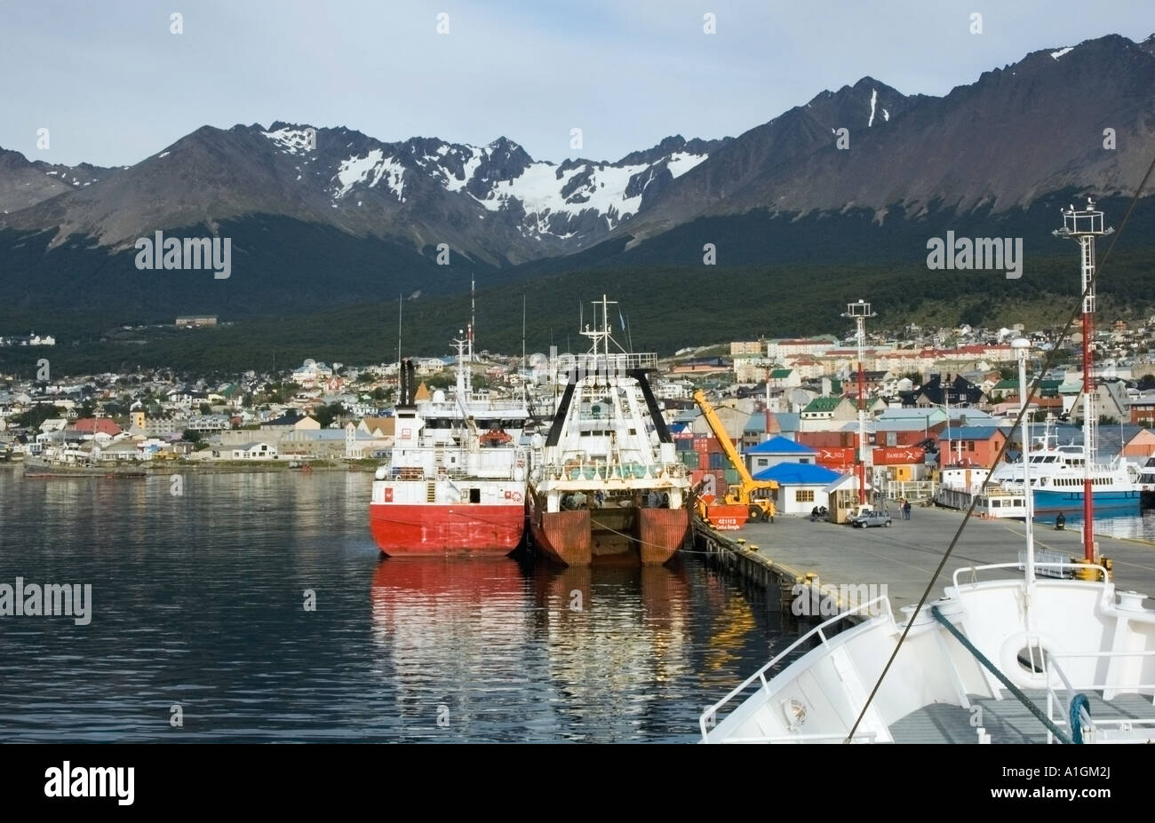 Boats in Ushuaia harbor with Andes Mountains Argentina Stock Photo - Alamy