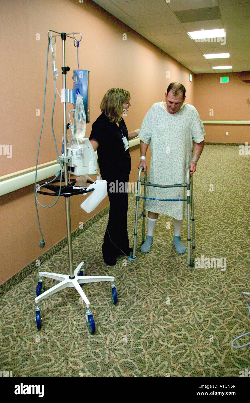 Therapist walking with male surgery patient, Nevada Stock Photo - Alamy