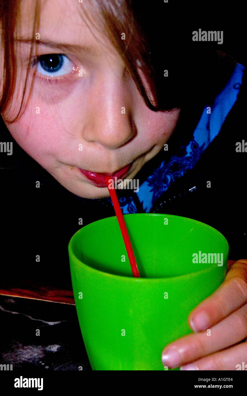 child drinking out of green beaker with red straw Stock Photo - Alamy