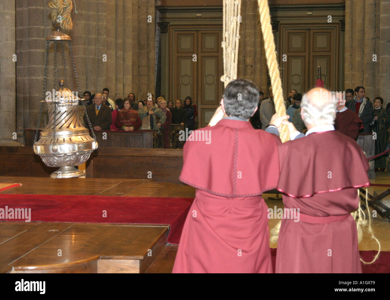 Two priests pulling up a smoking Botafumeiro in the Cathedral of ...
