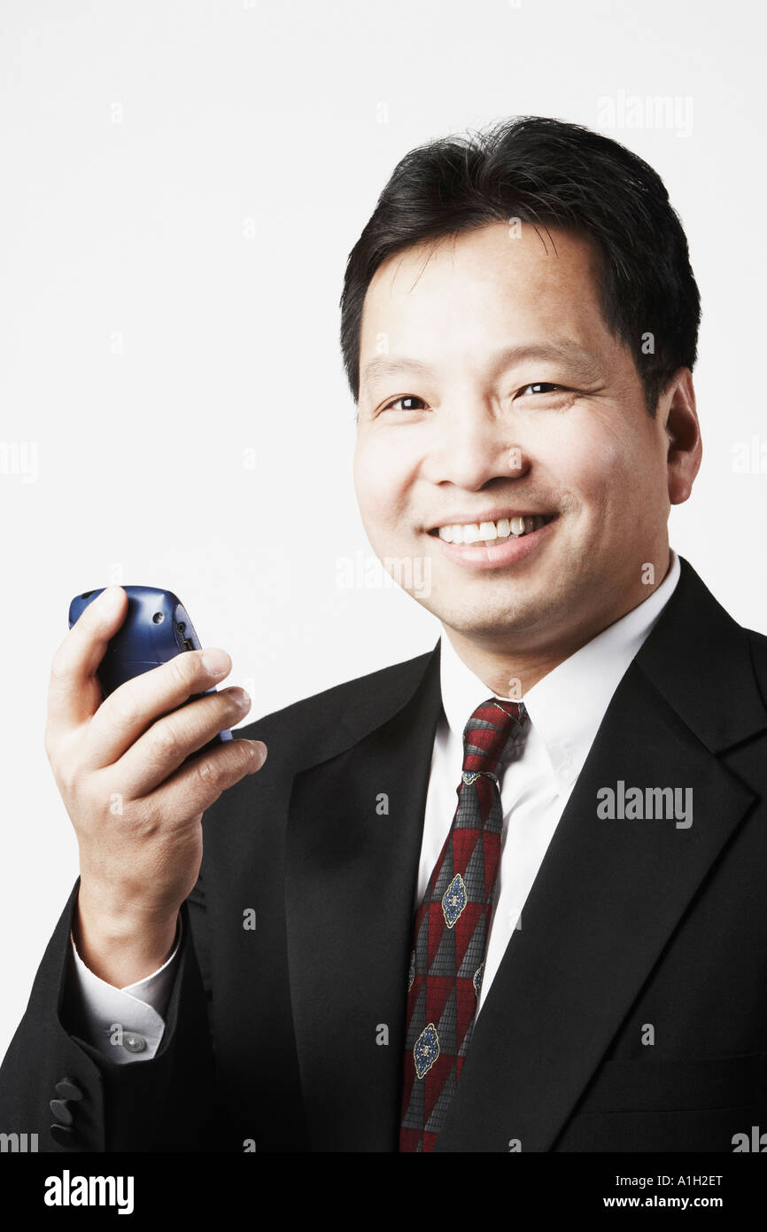 Portrait of a mid adult man holding a mobile phone smiling Stock Photo ...