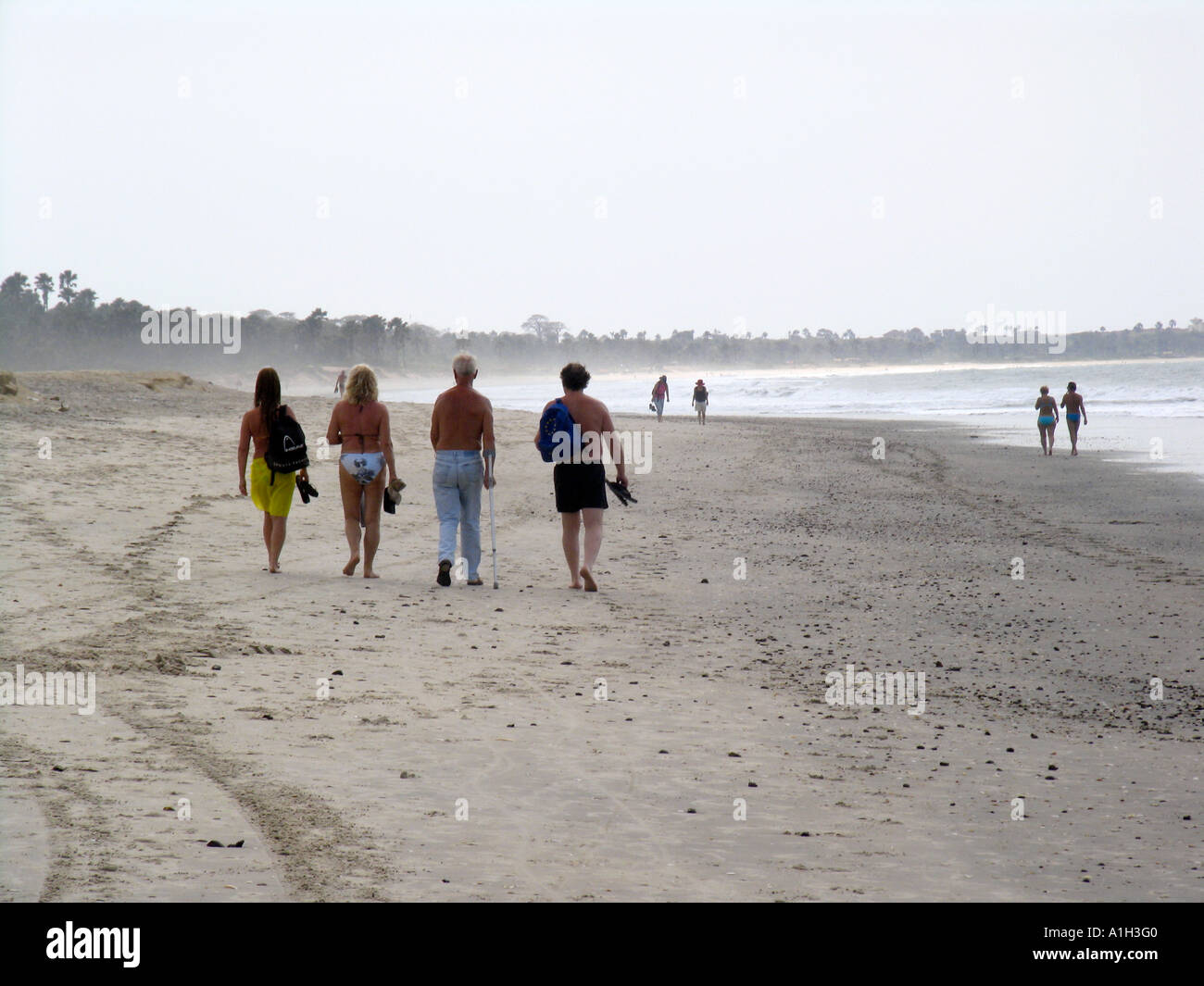 Visitors walk on Kololi Beach The Gambia Stock Photo - Alamy