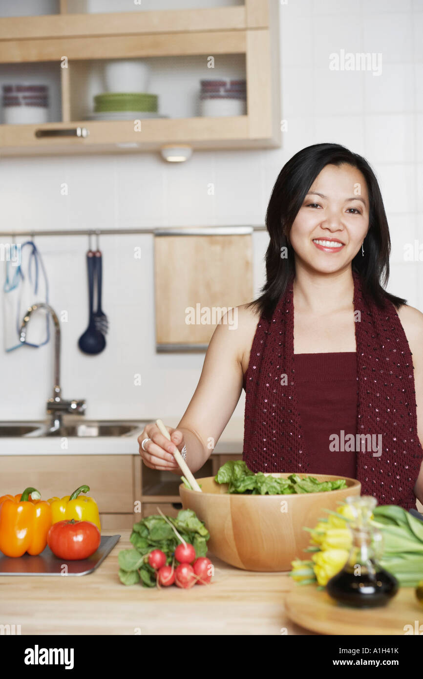 Portrait of a young woman preparing food in the kitchen smiling Stock ...