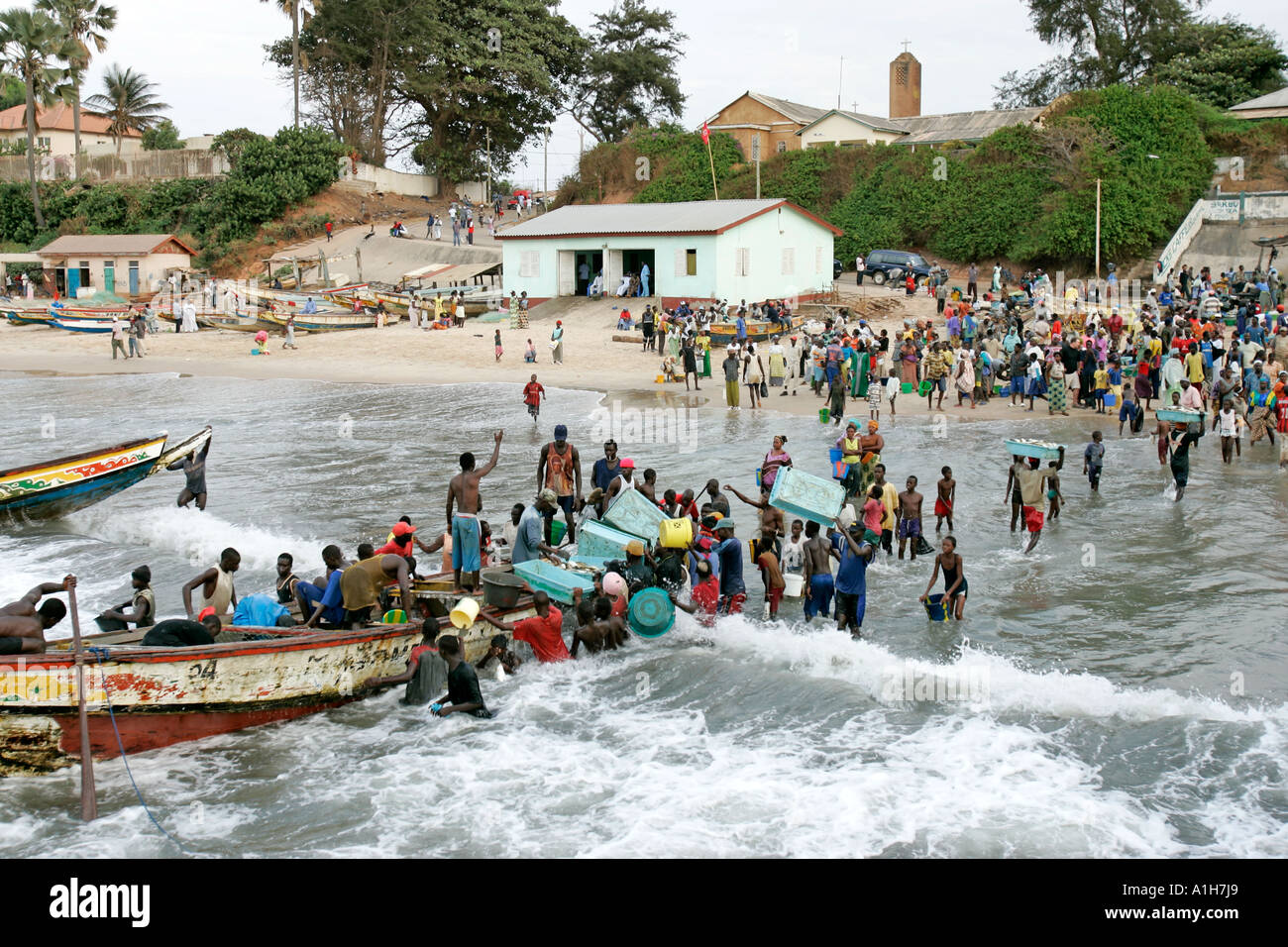Young men wade in surf unloading fishing boat Bakau The Gambia Stock ...