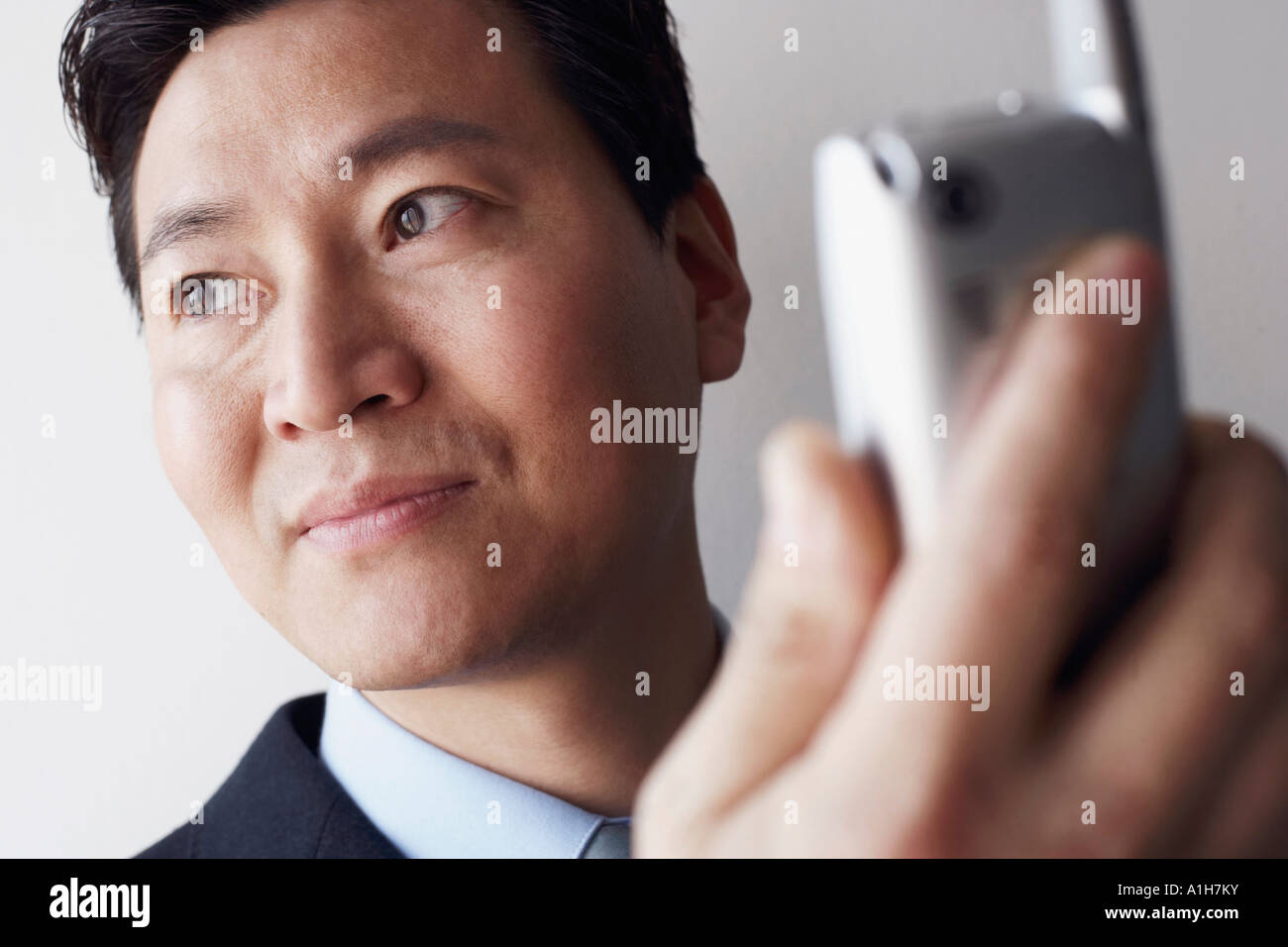 Close-up of a businessman holding a mobile phone thinking Stock Photo ...