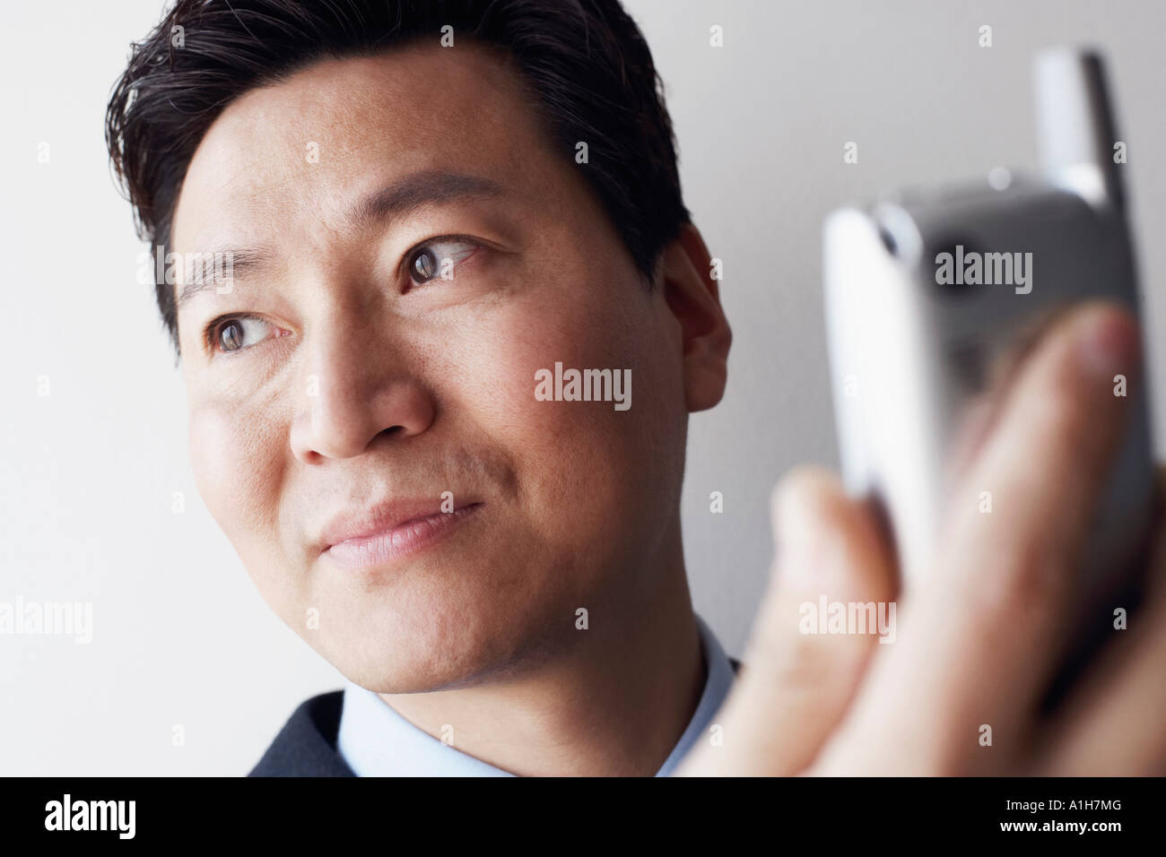 Close-up of a businessman holding a mobile phone thinking Stock Photo ...