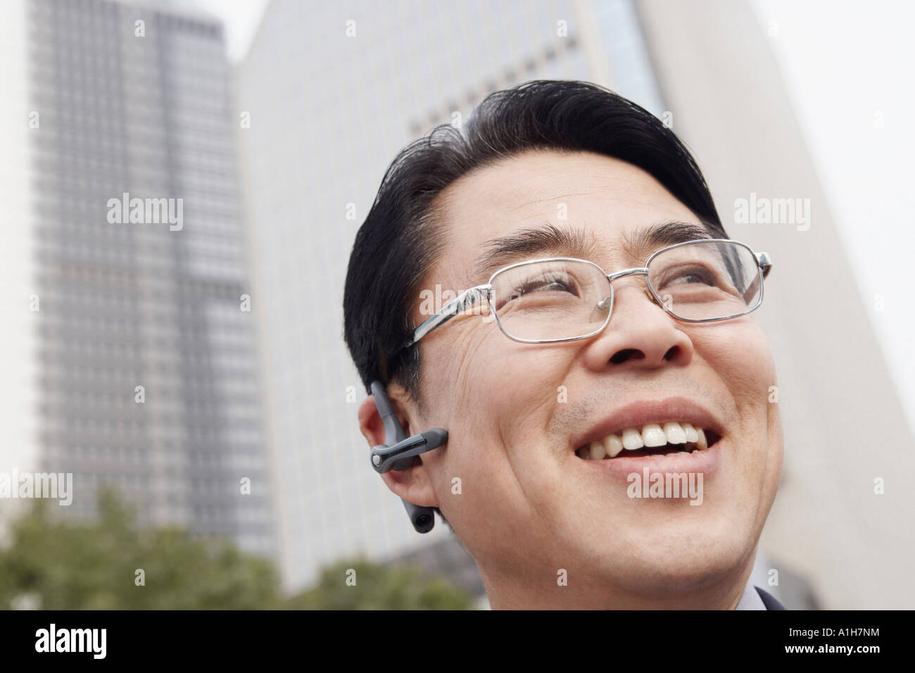 Low angle view of a businessman wearing a hands free device smiling ...