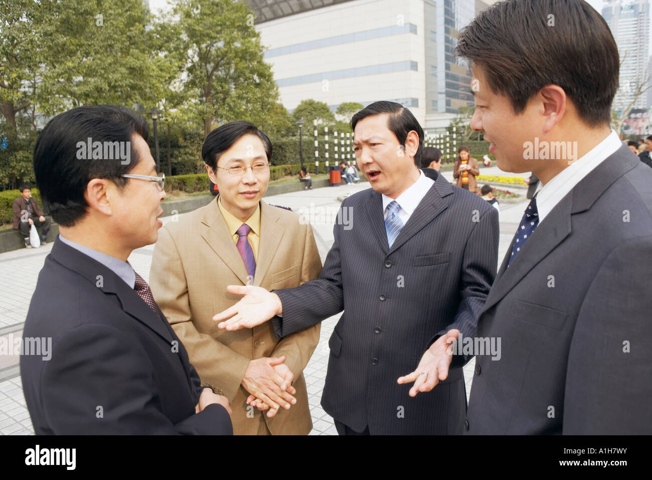 Close-up of four businessmen talking to each other Stock Photo - Alamy