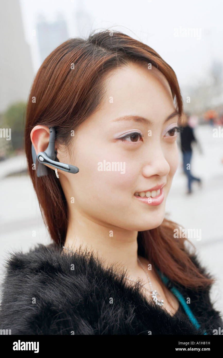 Close-up of a young woman wearing a hands free device Stock Photo - Alamy