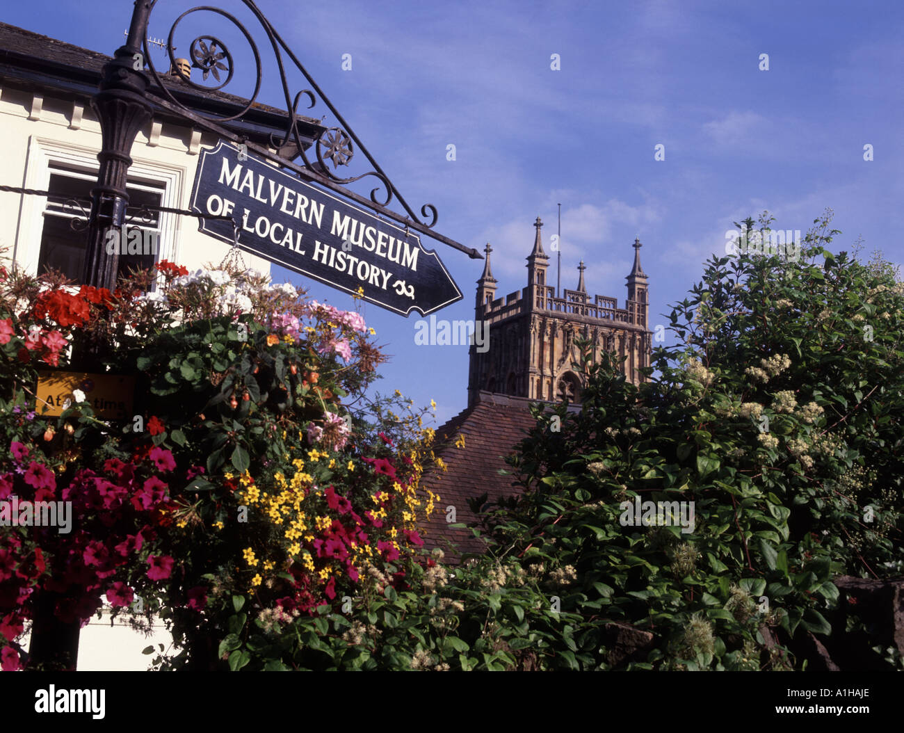A street light and a sign to the local museum with its hanging baskets ...