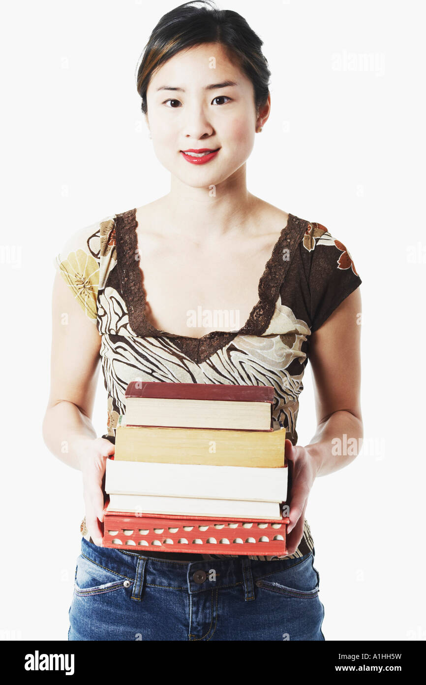 Portrait of a young woman holding books Stock Photo - Alamy