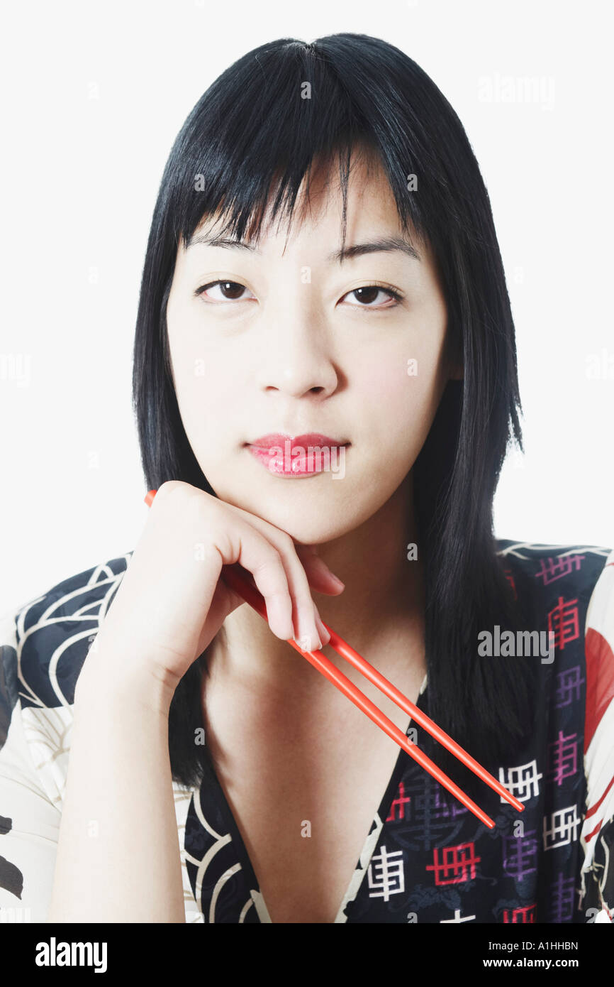 Portrait of a young woman holding chopsticks Stock Photo - Alamy