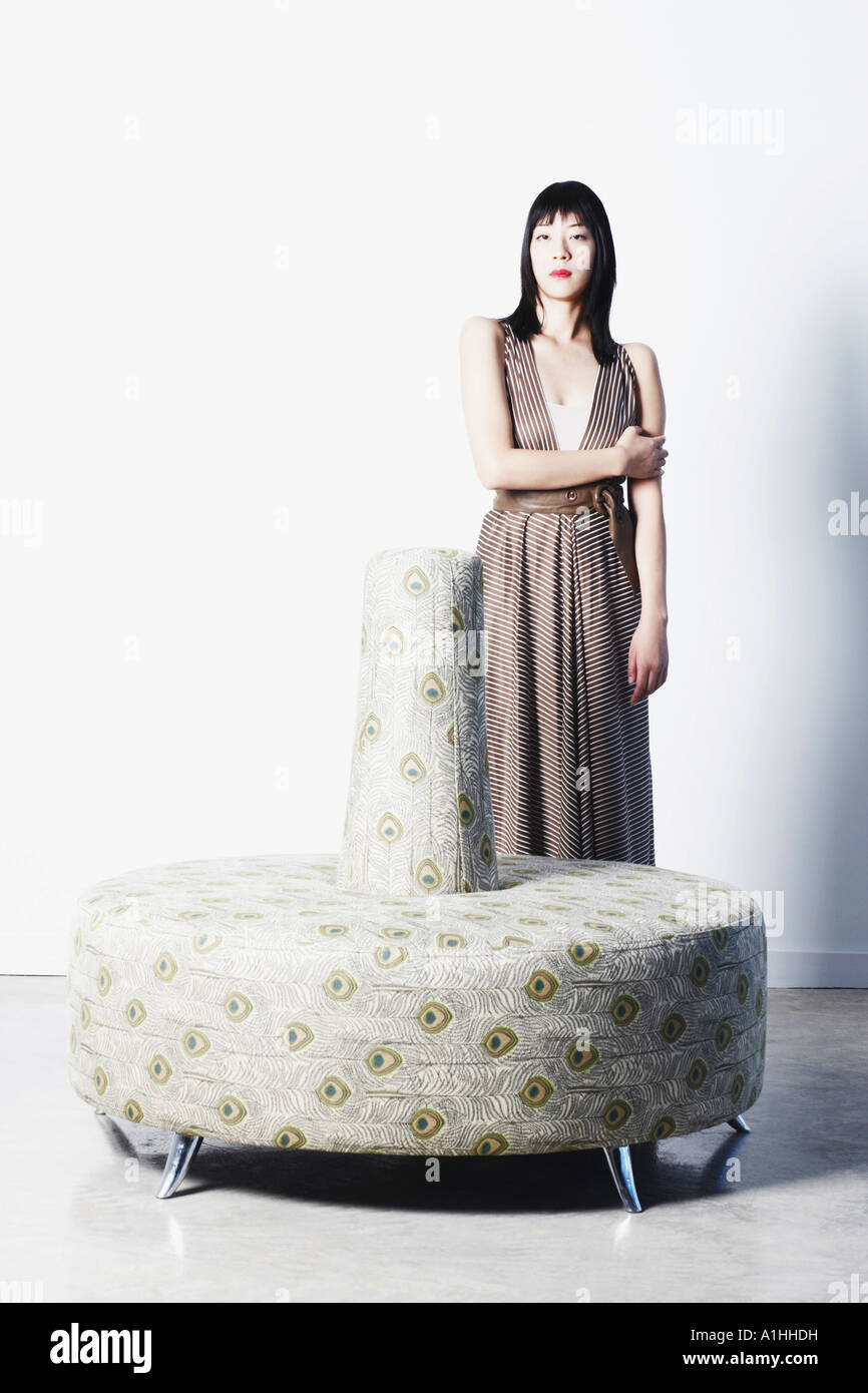 Portrait of a young woman standing behind a couch Stock Photo - Alamy