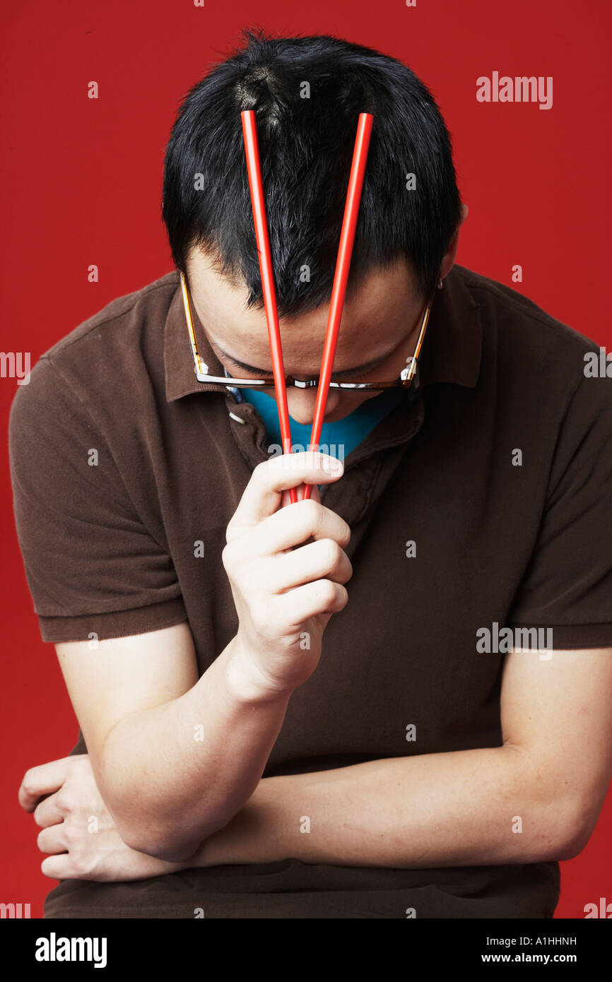 Close-up of a young man holding chopsticks on his head Stock Photo - Alamy