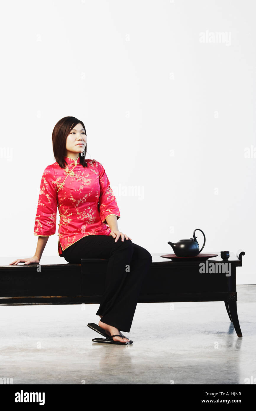 Young woman sitting on a table Stock Photo - Alamy