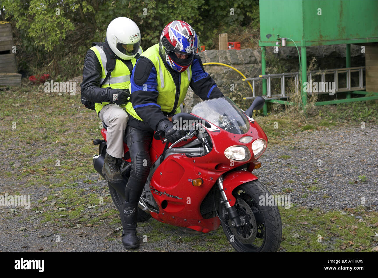 Two senior bikers on a red Triumph Daytona 955 motor bike wearing high ...