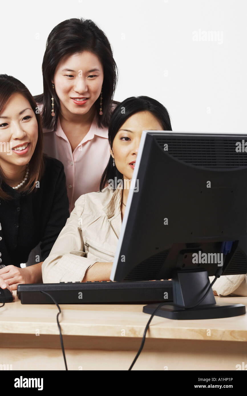 Three businesswomen looking at a computer Stock Photo - Alamy