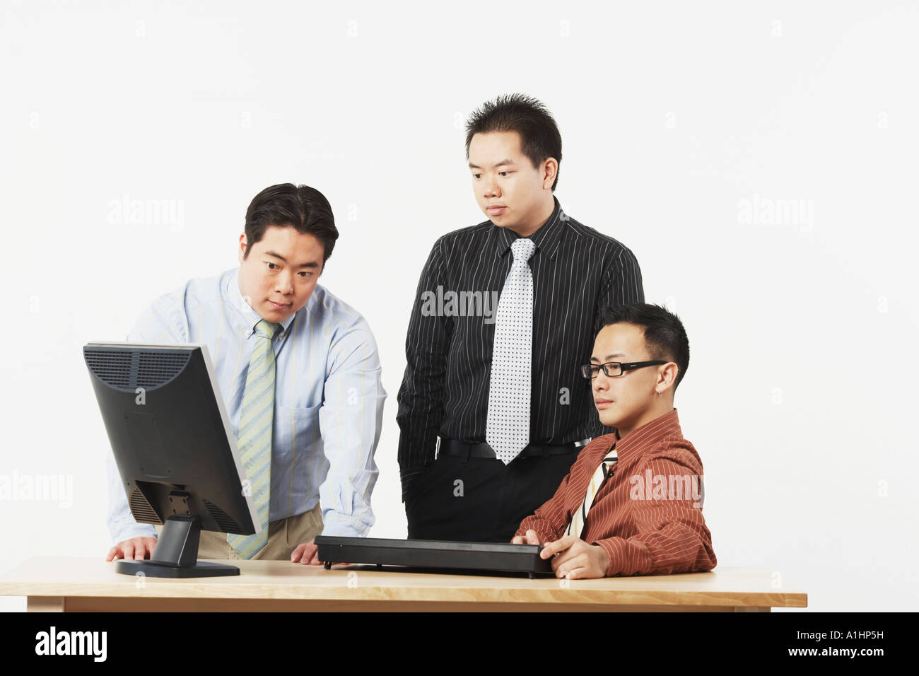 Three businessmen looking at a computer monitor Stock Photo - Alamy
