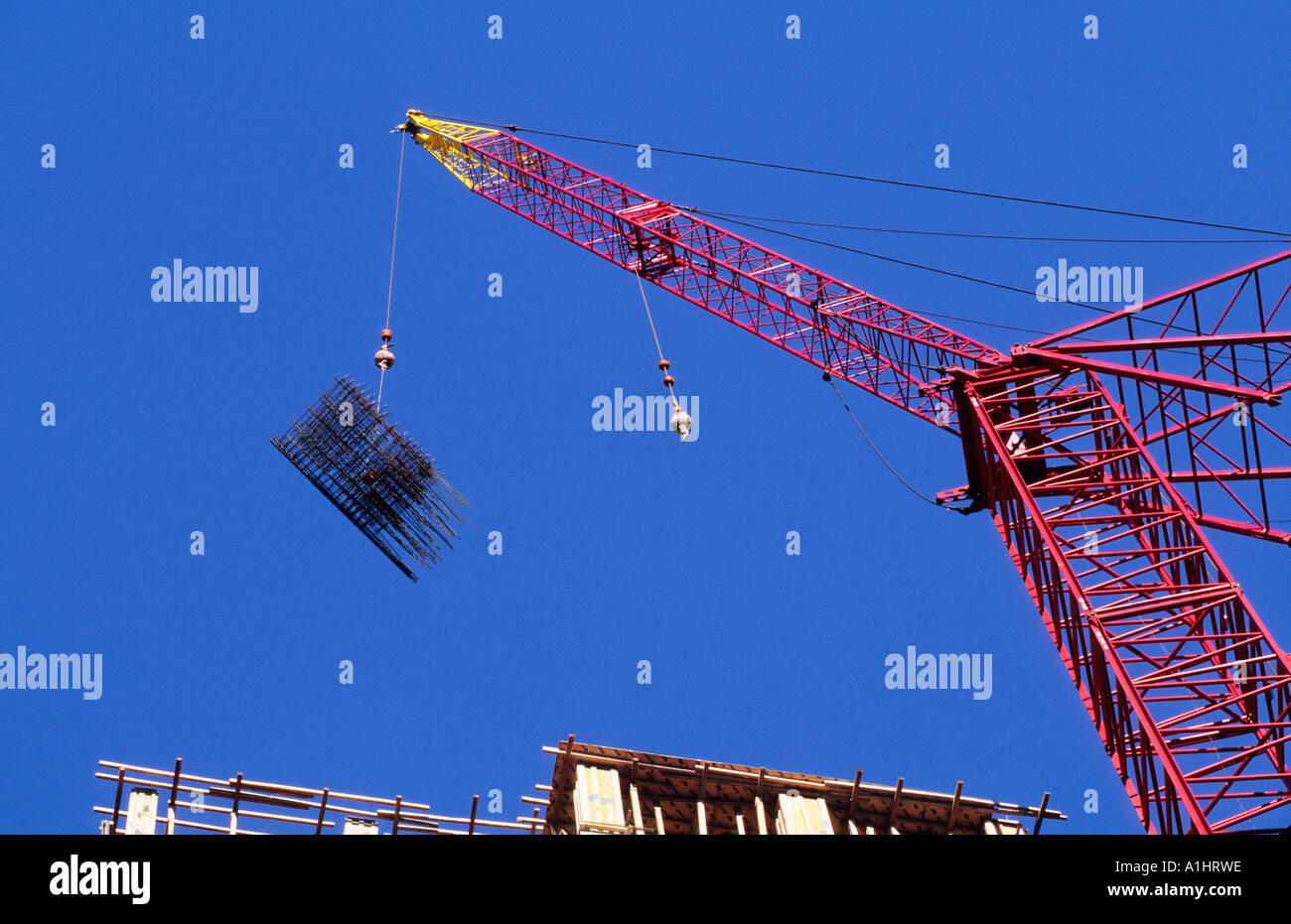 Construction sit, Manhattan. Huge red crane hoisting metal sheet above ...