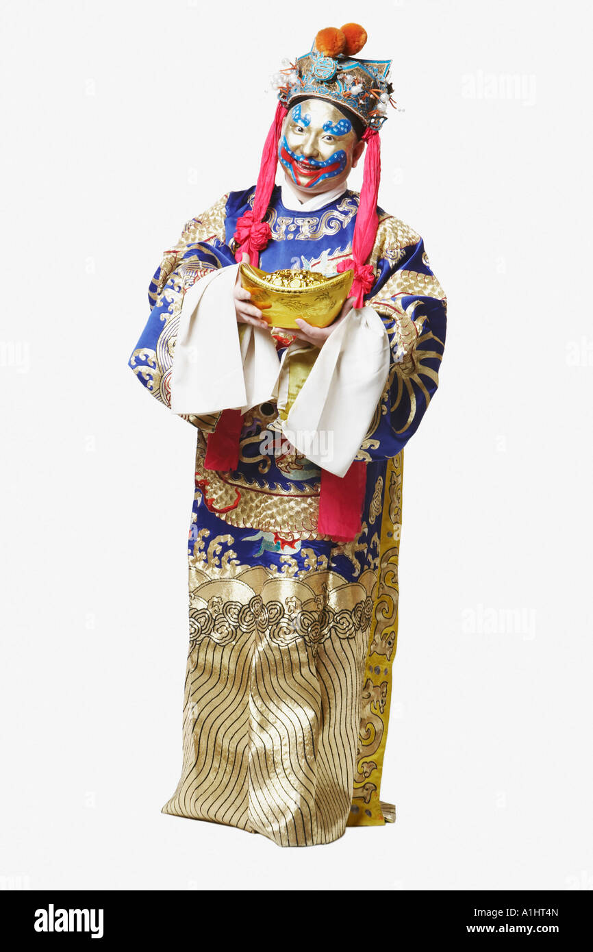 Portrait of a male Chinese opera performer holding a bowl full of gold ...
