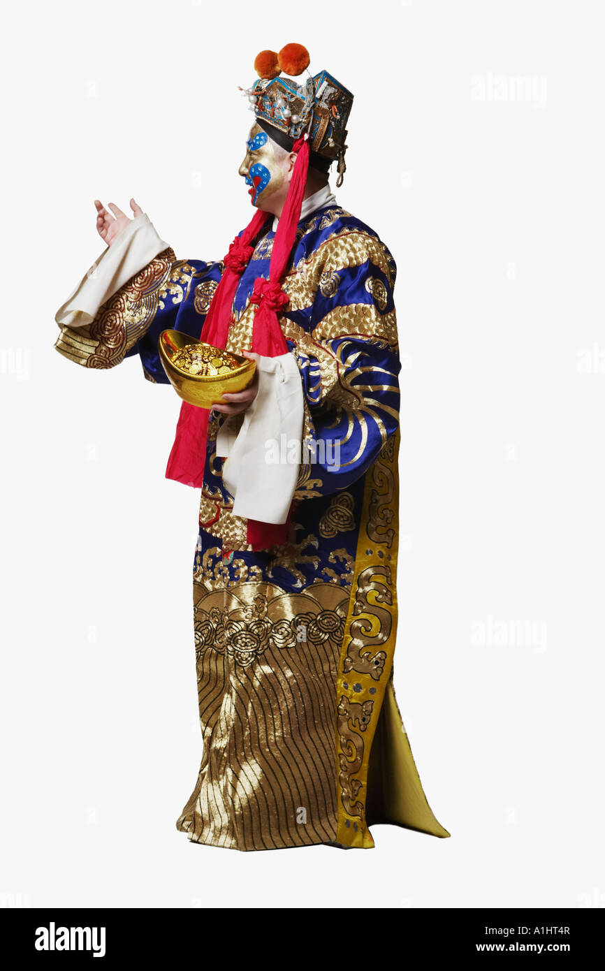 Side profile of a male Chinese opera performer holding a bowl full of ...