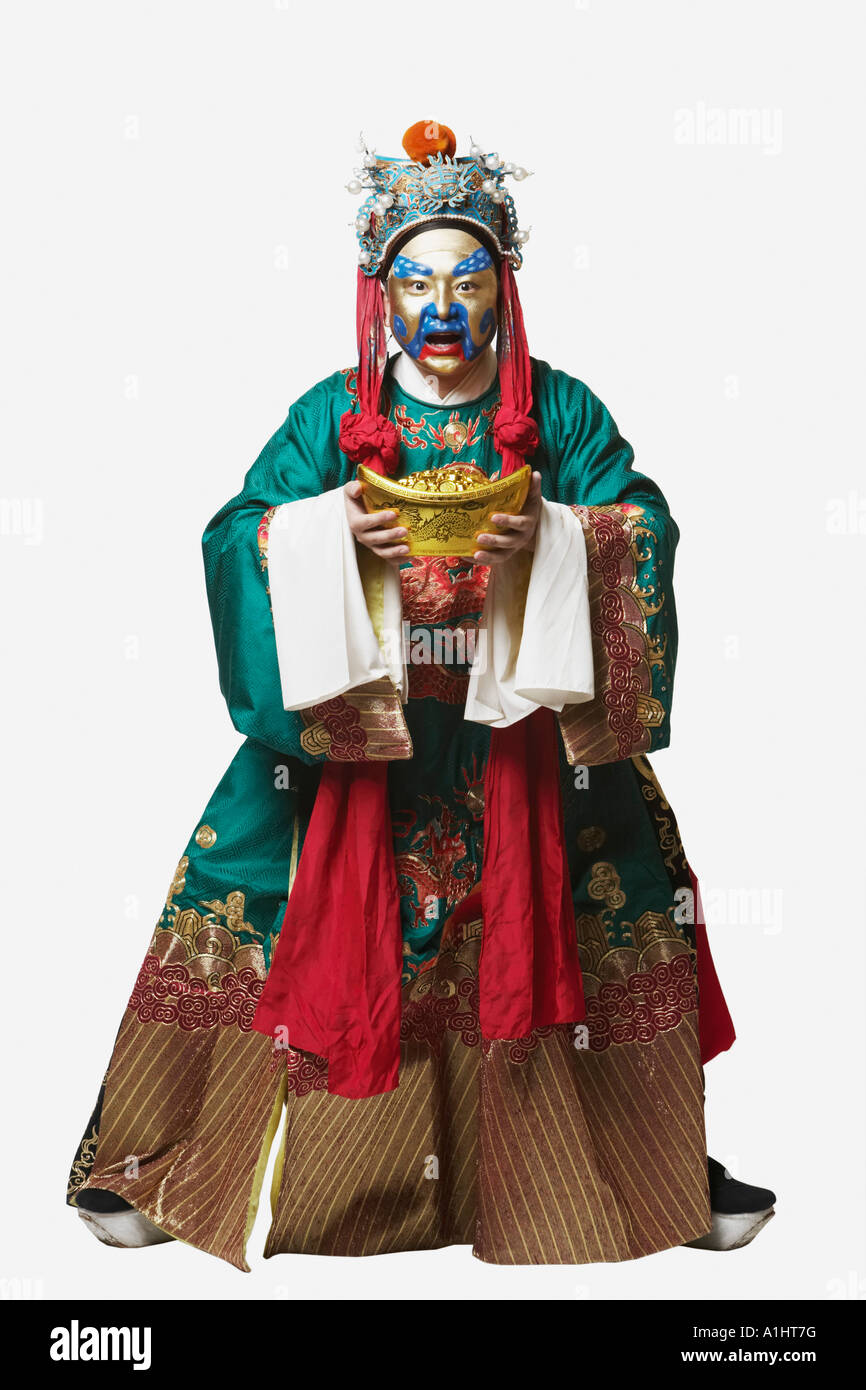 Portrait of a male Chinese opera performer holding a bowl full of gold ...