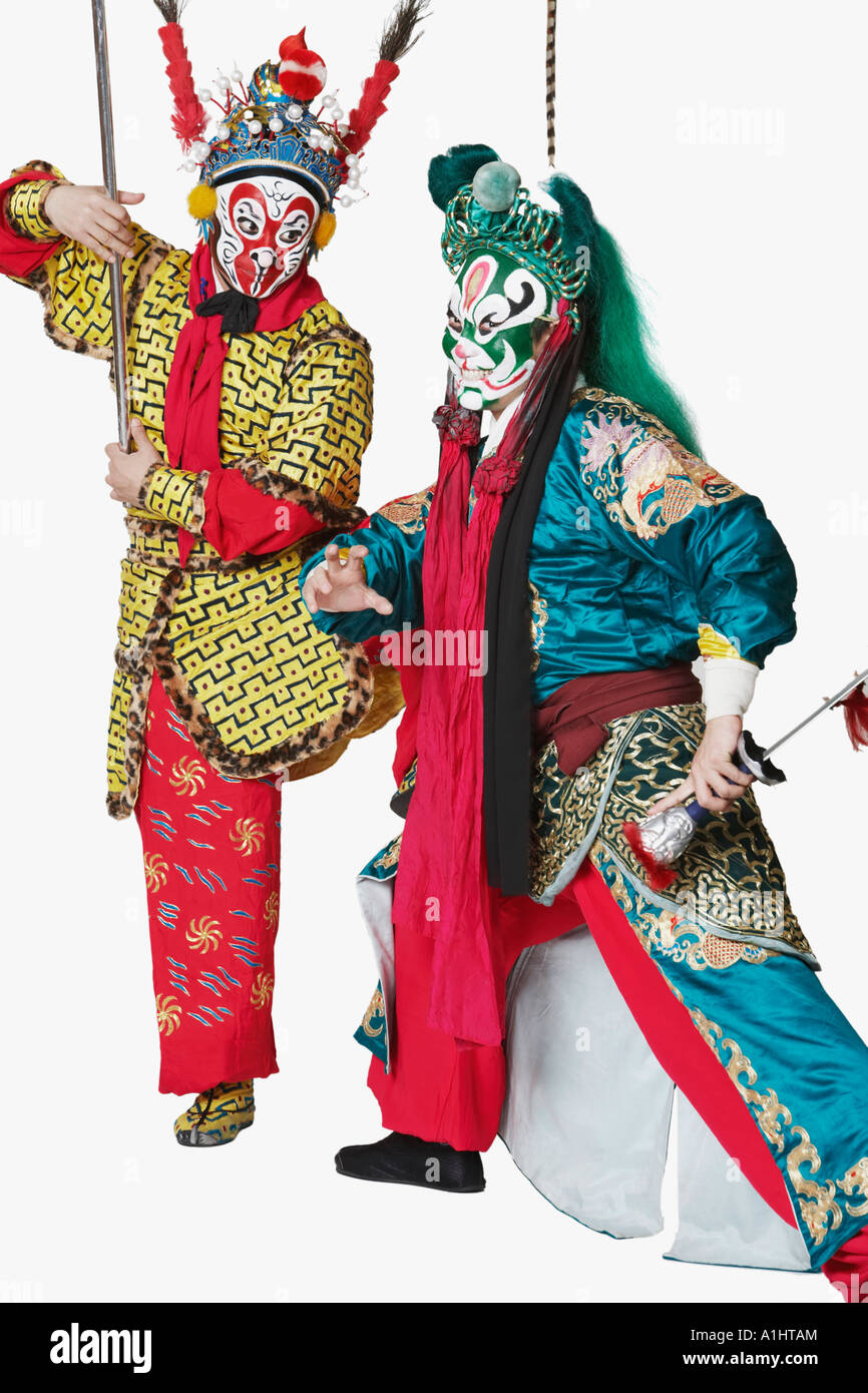 Two male Chinese opera performers gesturing with weapons Stock Photo ...